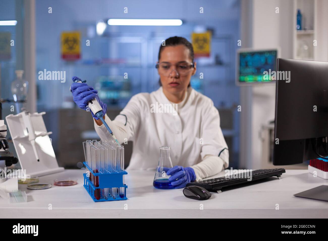 Professional laboratory worker using pipette for jar container in ...