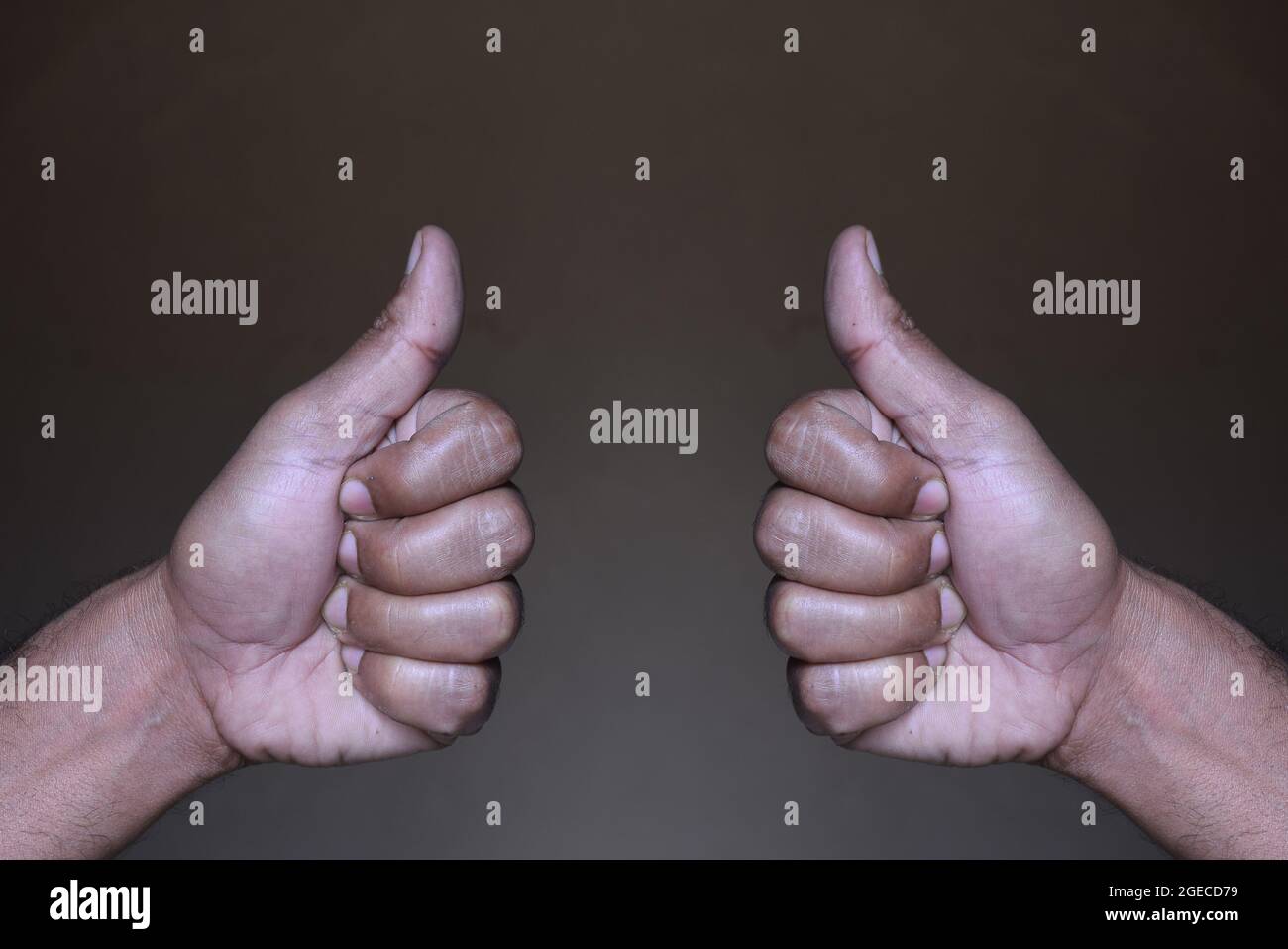 Closeup view of two hands giving both thumbs up as sign of likeness or ...