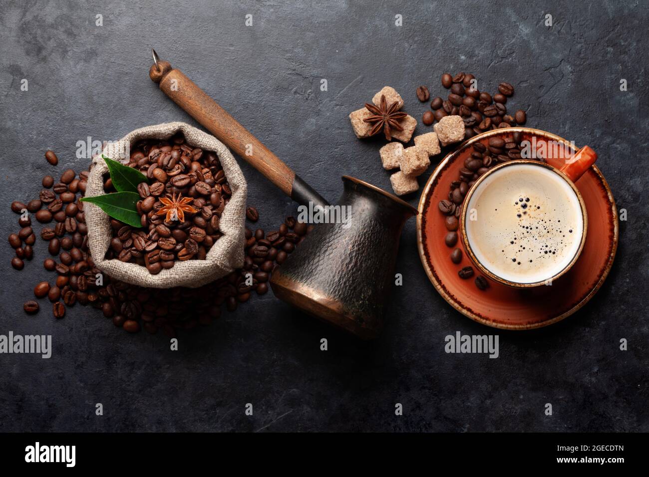 Roasted coffee beans, Turkish jezve, espresso coffee cup and brown sugar. Top view flat lay ...