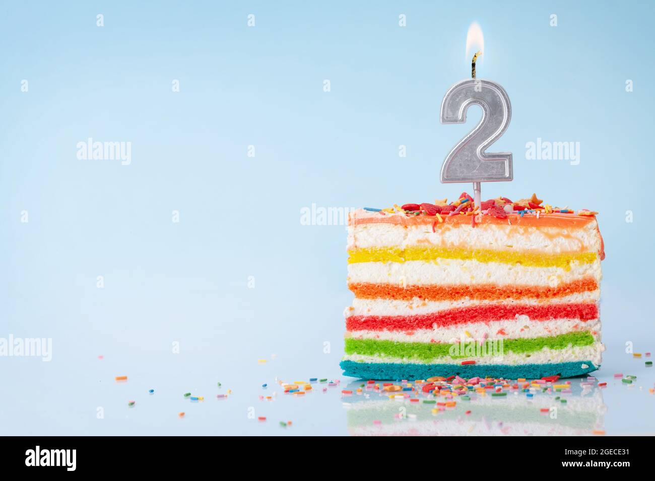 Birthday cake with number two candle on a blue background with copy ...