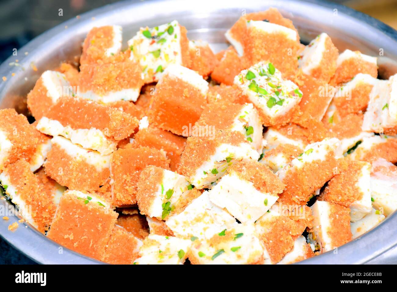 Famous Indian sweets placed in steel plates, made from milk.Selective ...