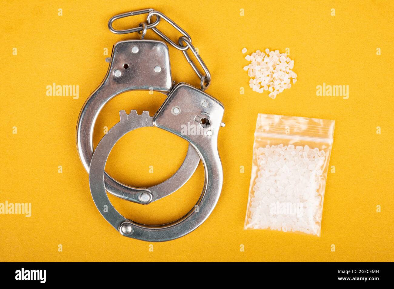 crystal drugs and handcuffs on yellow background, white powder drug ...