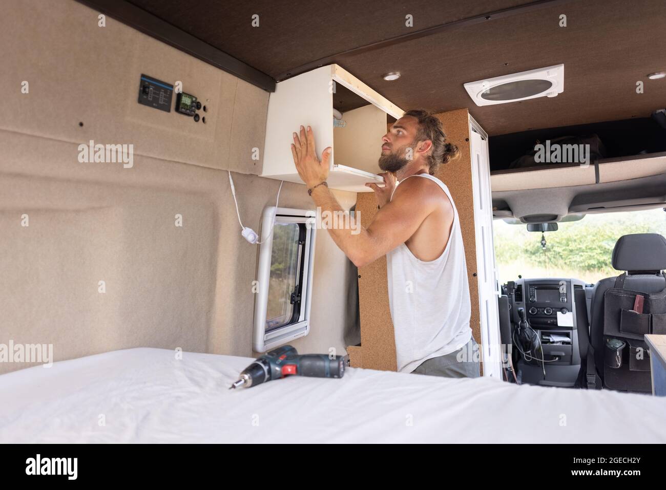 Man building a small cupboard into a camper van Stock Photo - Alamy