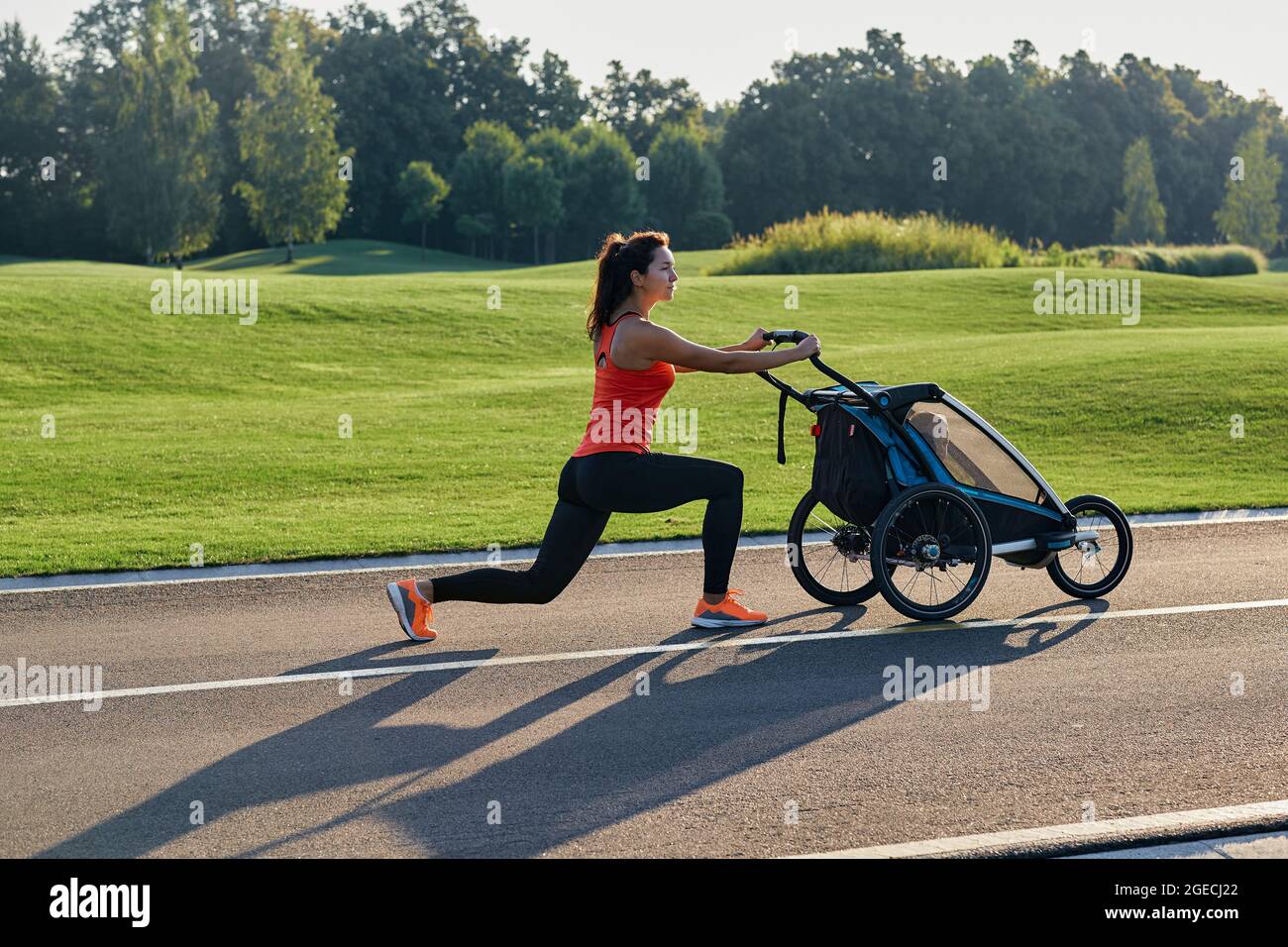 Young mother is doing exercise, gymnastics and a workout outdoor with ...
