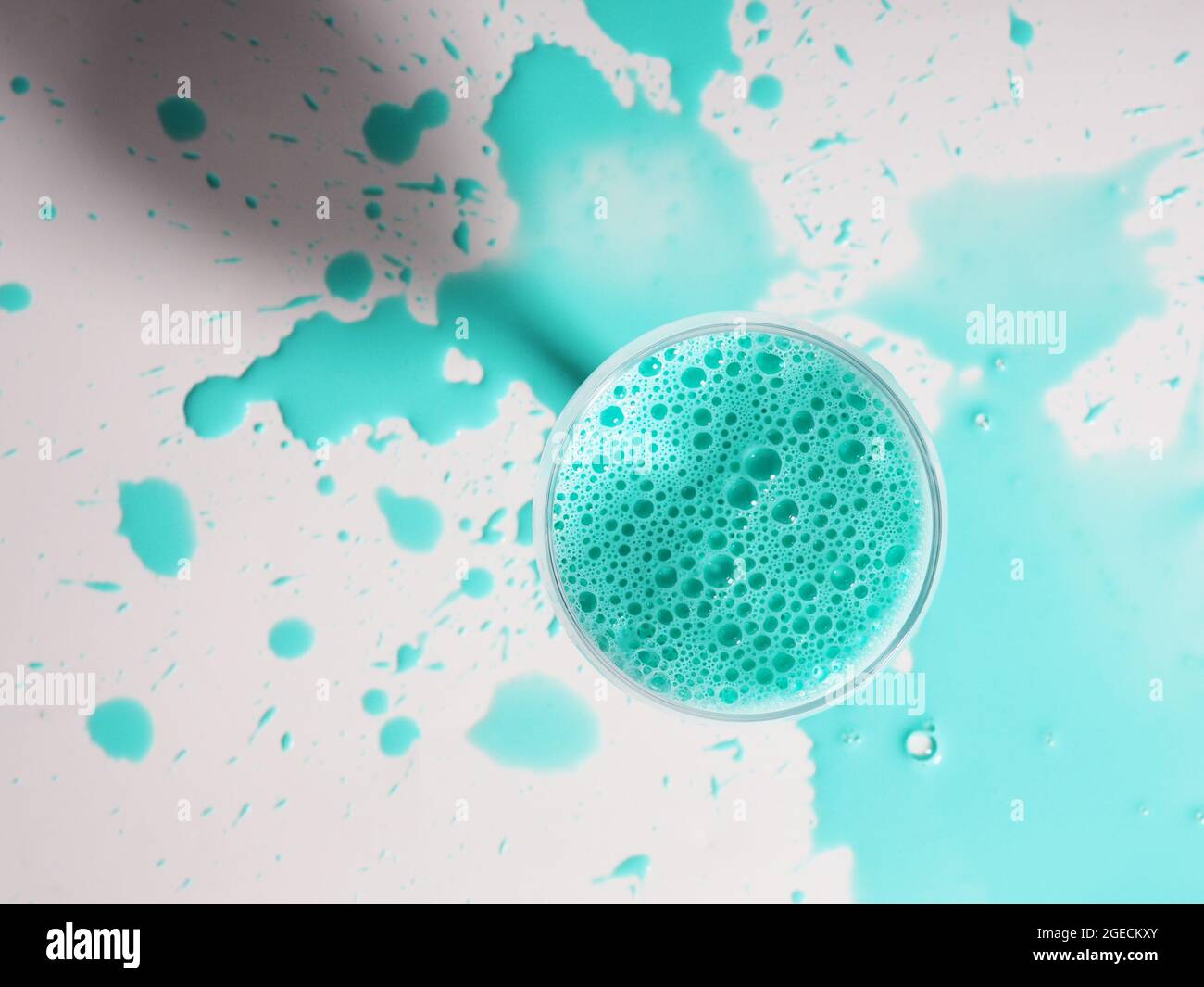 Glass with spilled mint liquid on a white background Stock Photo - Alamy