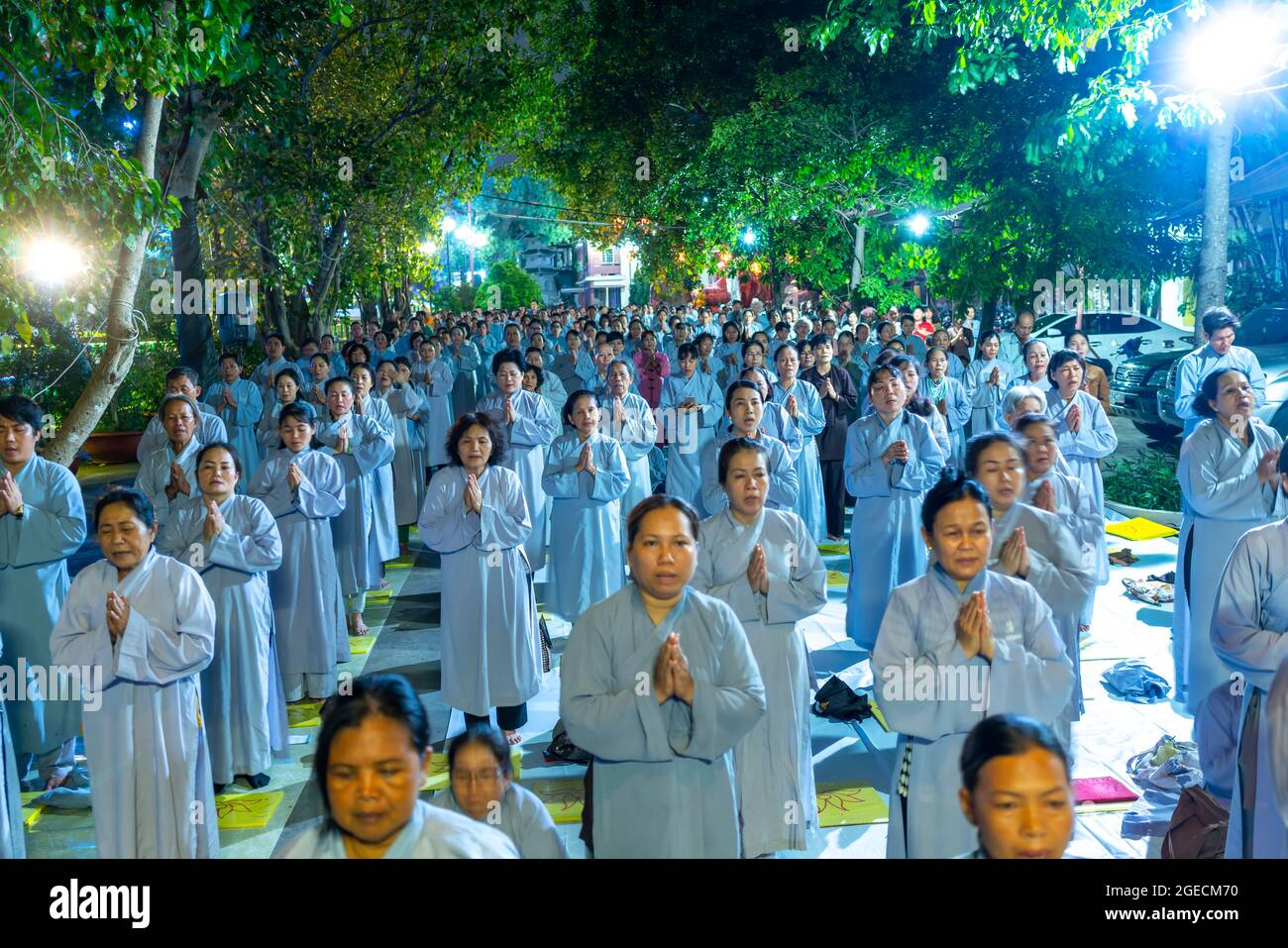 Monks and Buddhists are reverently bowing to Buddha during evening ...
