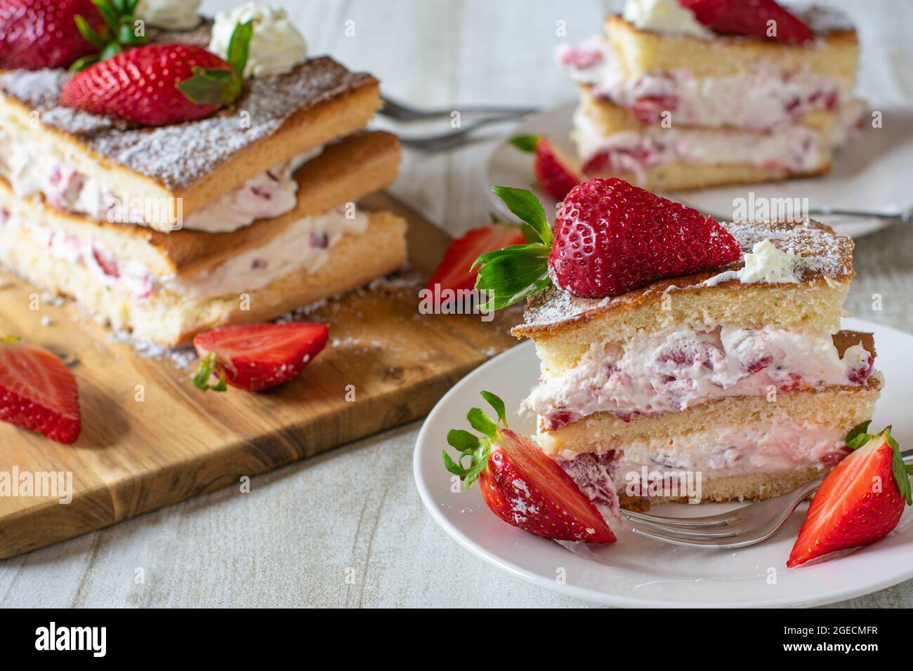 Homemade strawberry cream cake on rustic table background Stock Photo ...