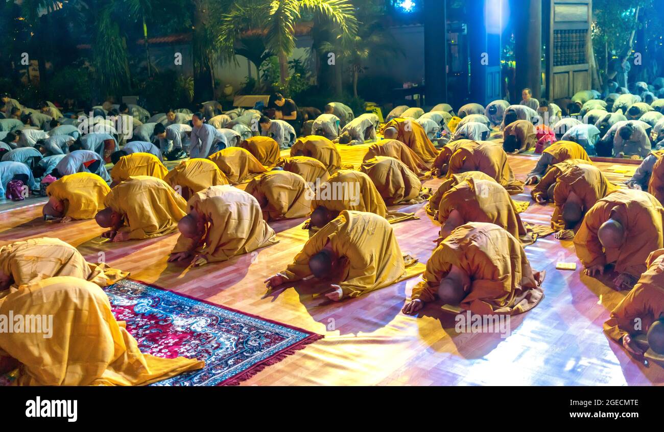 Monks are reverently bowing to Buddha during evening ceremony for ...