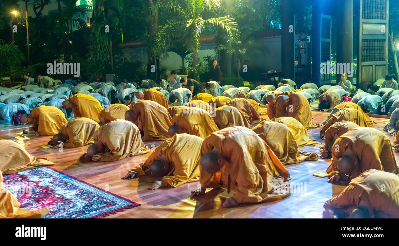 Monks are reverently bowing to Buddha during evening ceremony for ...
