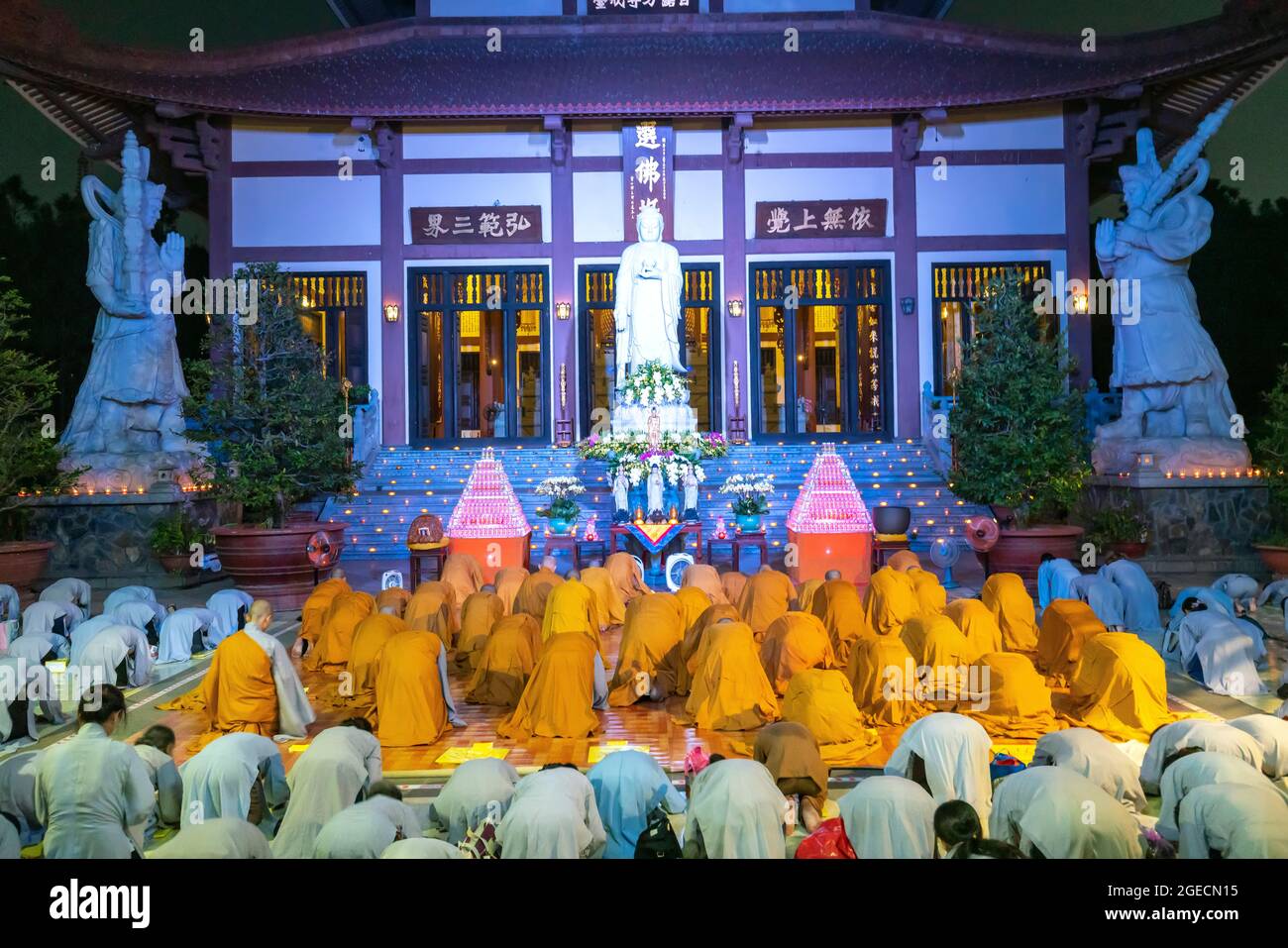 Monks are reverently bowing to Buddha during evening ceremony for ...