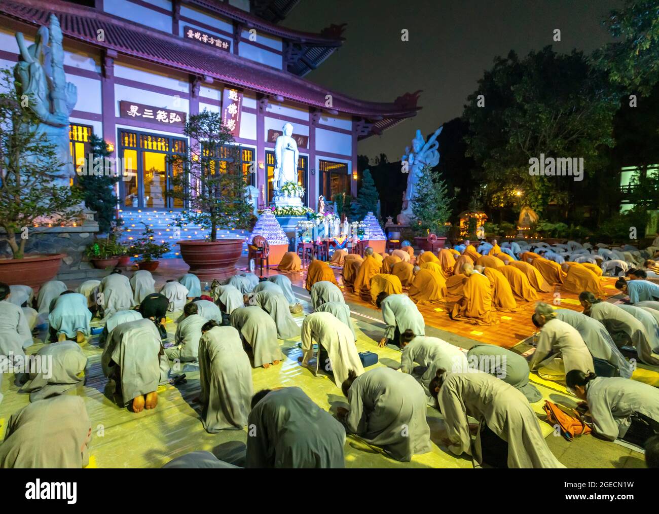 Monks are reverently bowing to Buddha during evening ceremony for ...