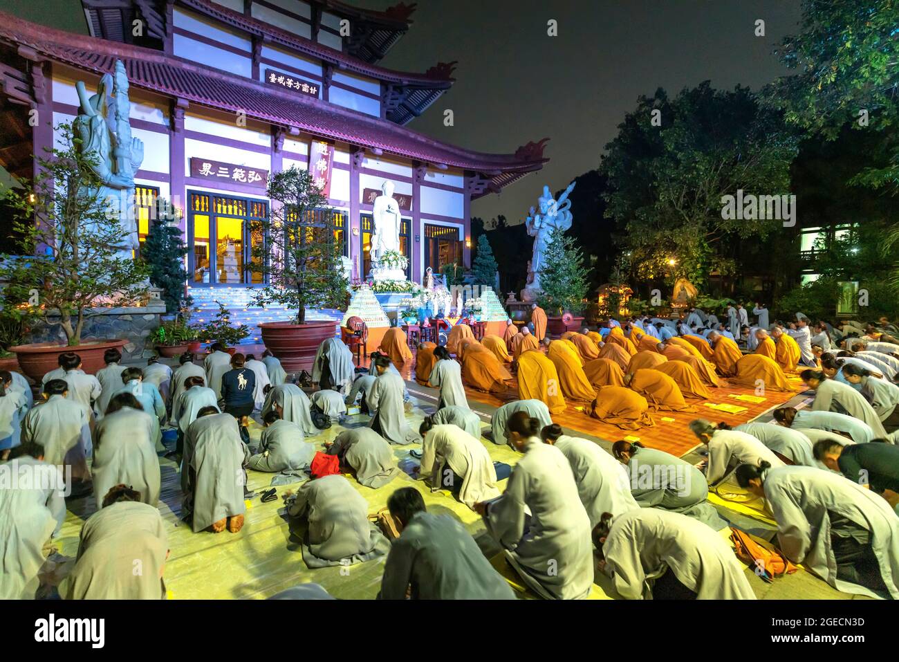 Monks are reverently bowing to Buddha during evening ceremony for ...