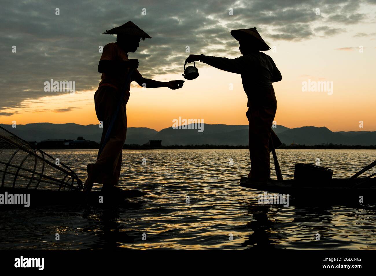 Myanmar, Shan state, Inle lake, two fishermen drinking tea at dusk ...