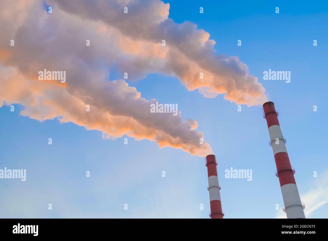 Factory smokestacks emitting smoke against sky - environmental ...