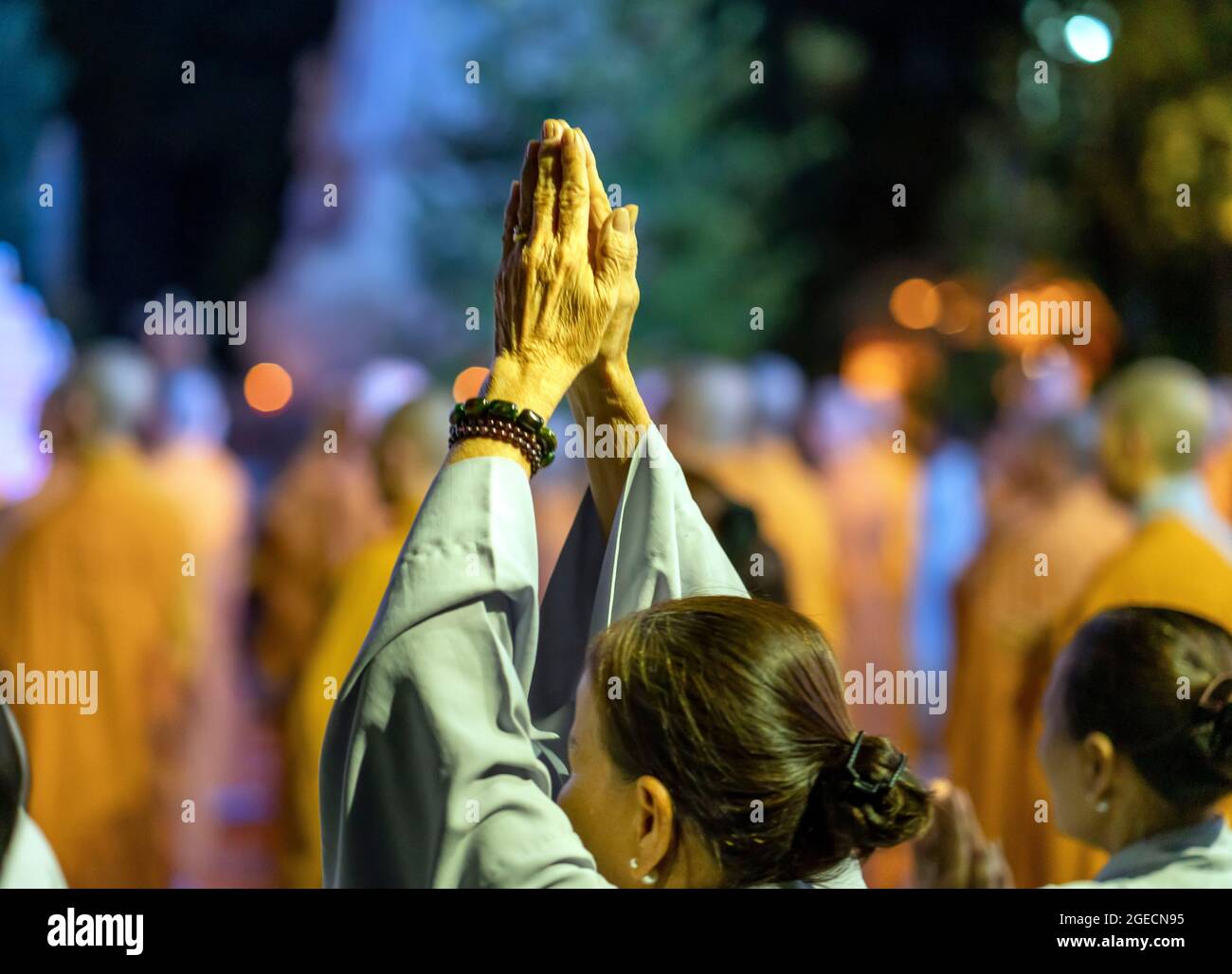 Buddhists are reverently bowing to Buddha during evening ceremony for ...