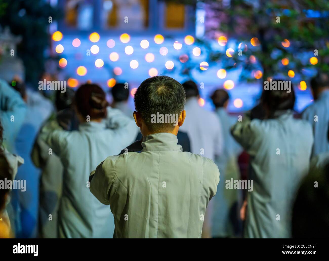 Buddhists are reverently bowing to Buddha during evening ceremony for ...