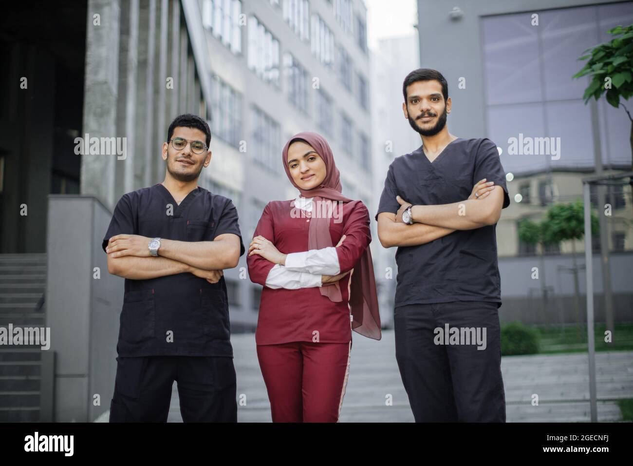 Front view of high-skilled team of three young confident Asian Arab ...