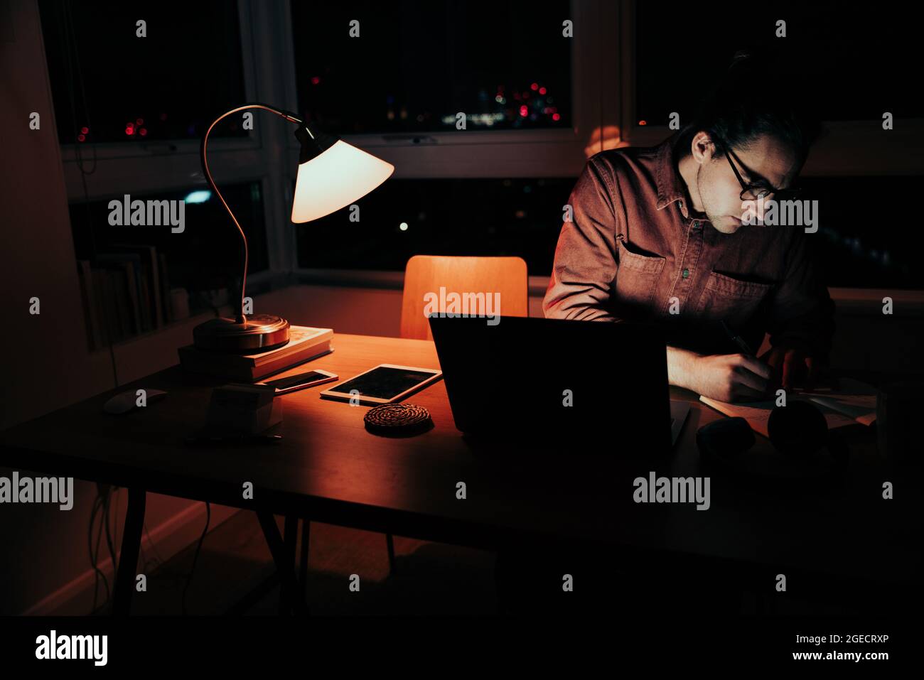 Caucasian business man working late at night organising week plans ...