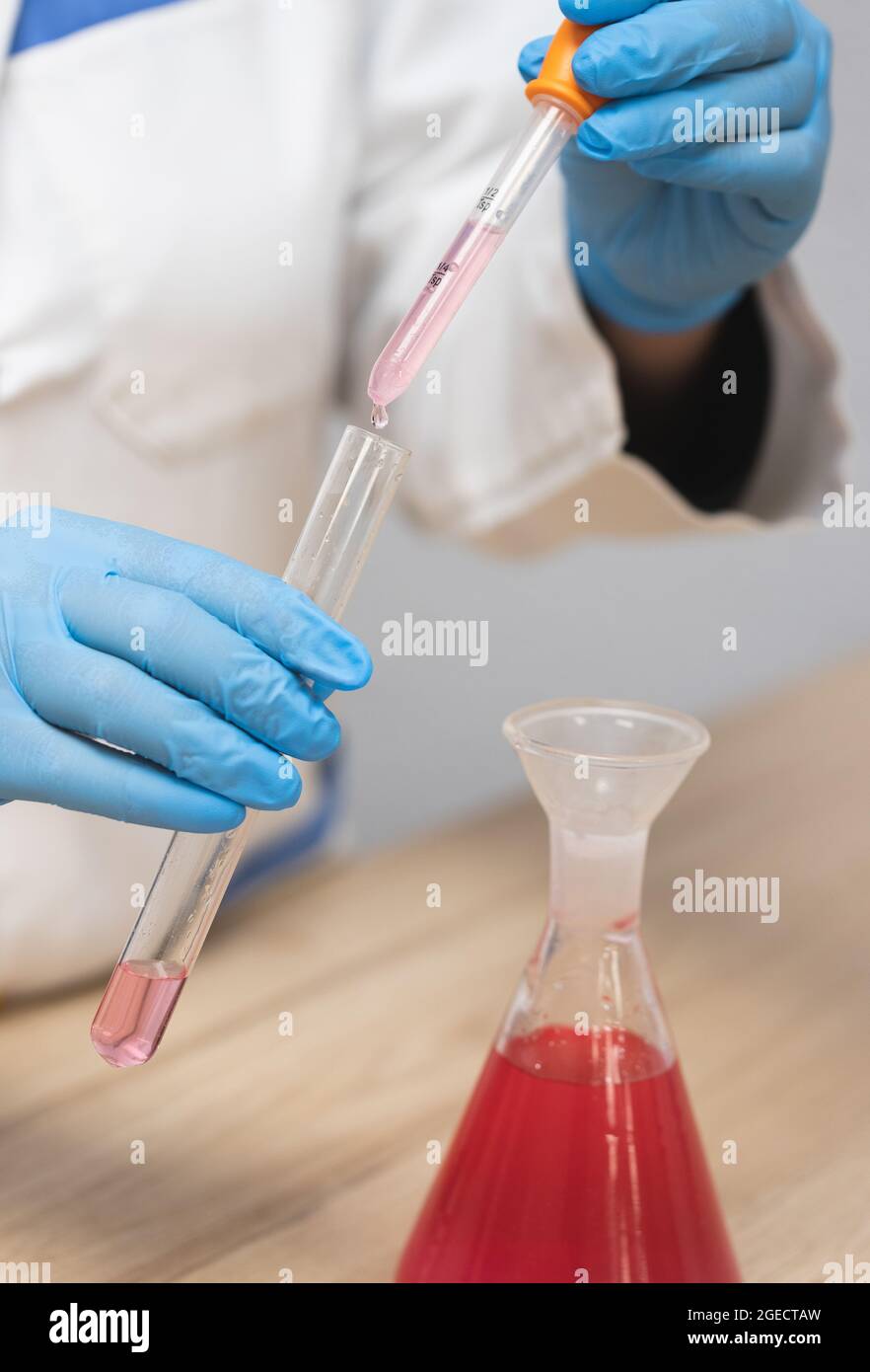 Laboratory technician working with an Erlenmeyer flask and a test tube ...