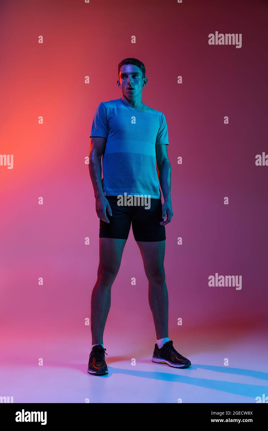 Portrat of Caucasian young sportive man in sportswear standing isolated ...