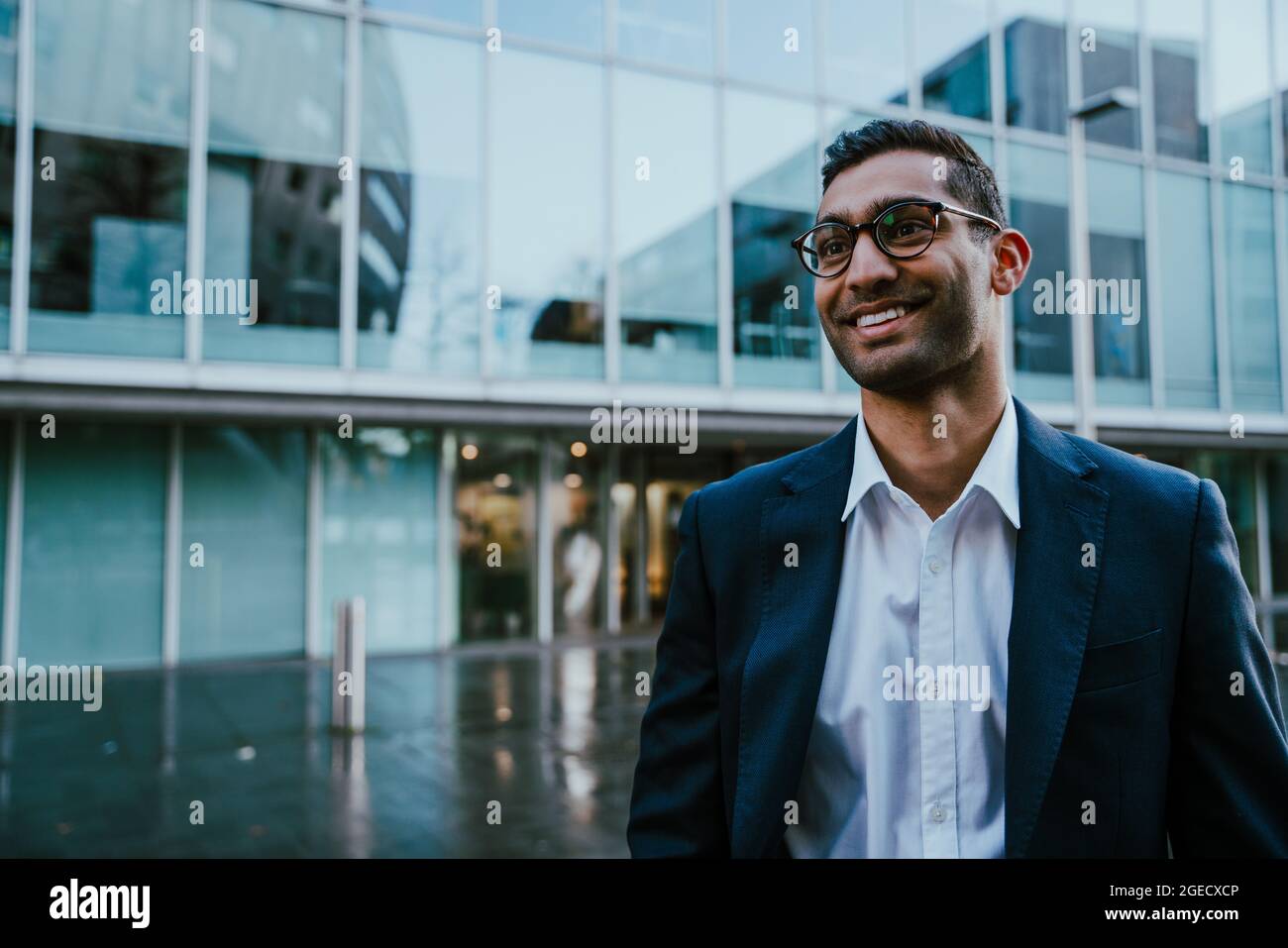 Portrait of young successful businessman smiling standing outside ...