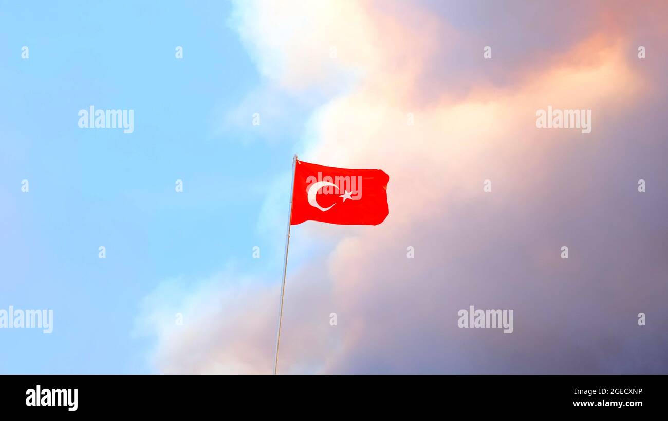Turkey flag close-up on a background of forest fire smoke clouds ...