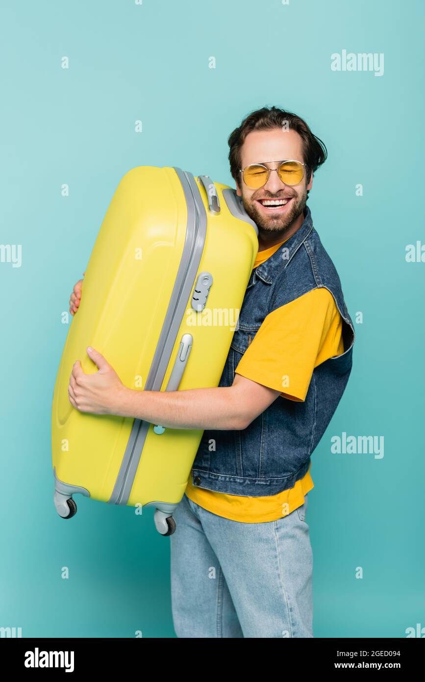 Cheerful man hugging suitcase hi-res stock photography and images - Alamy