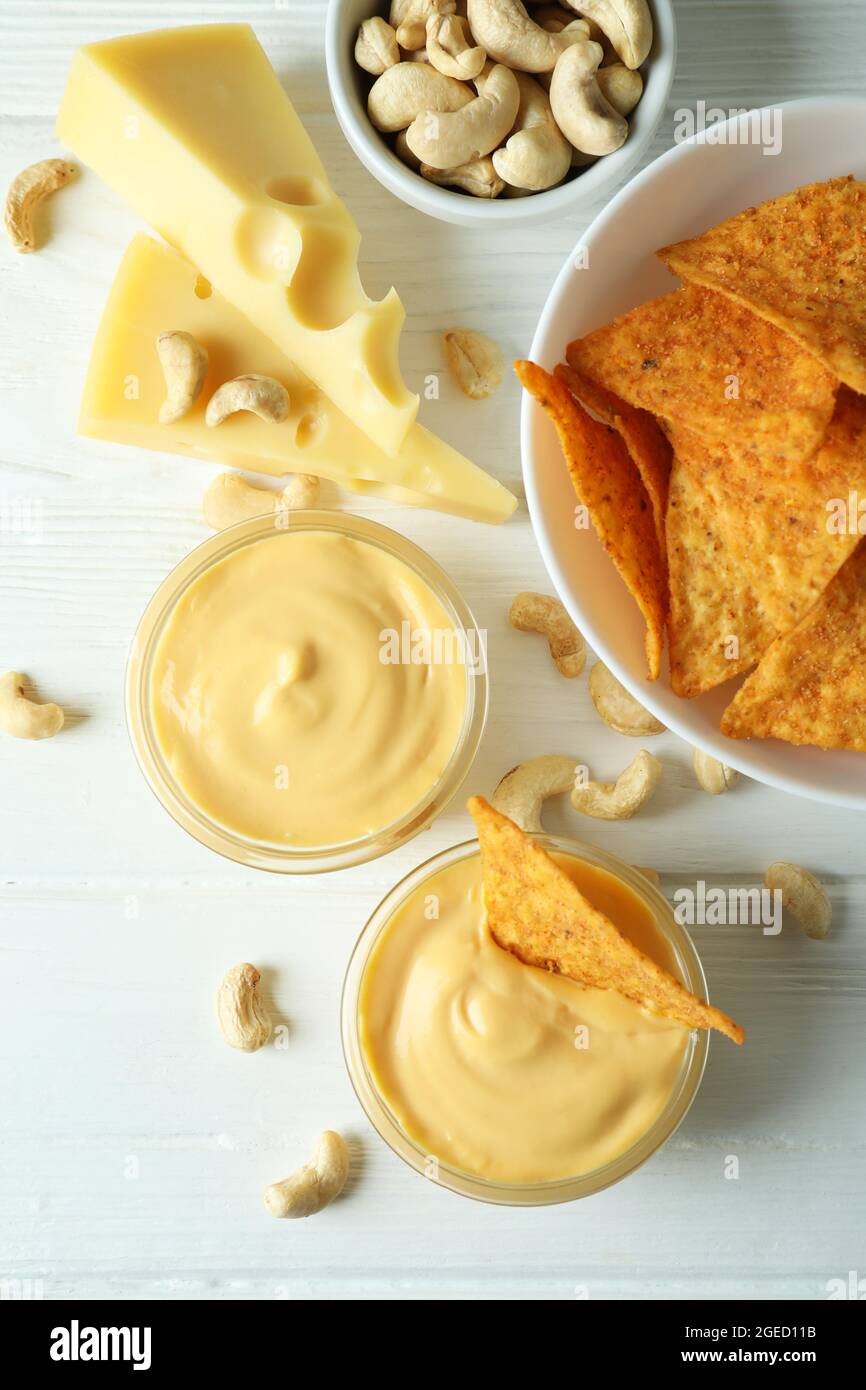 Snacks with cheese sauce on white wooden table Stock Photo - Alamy