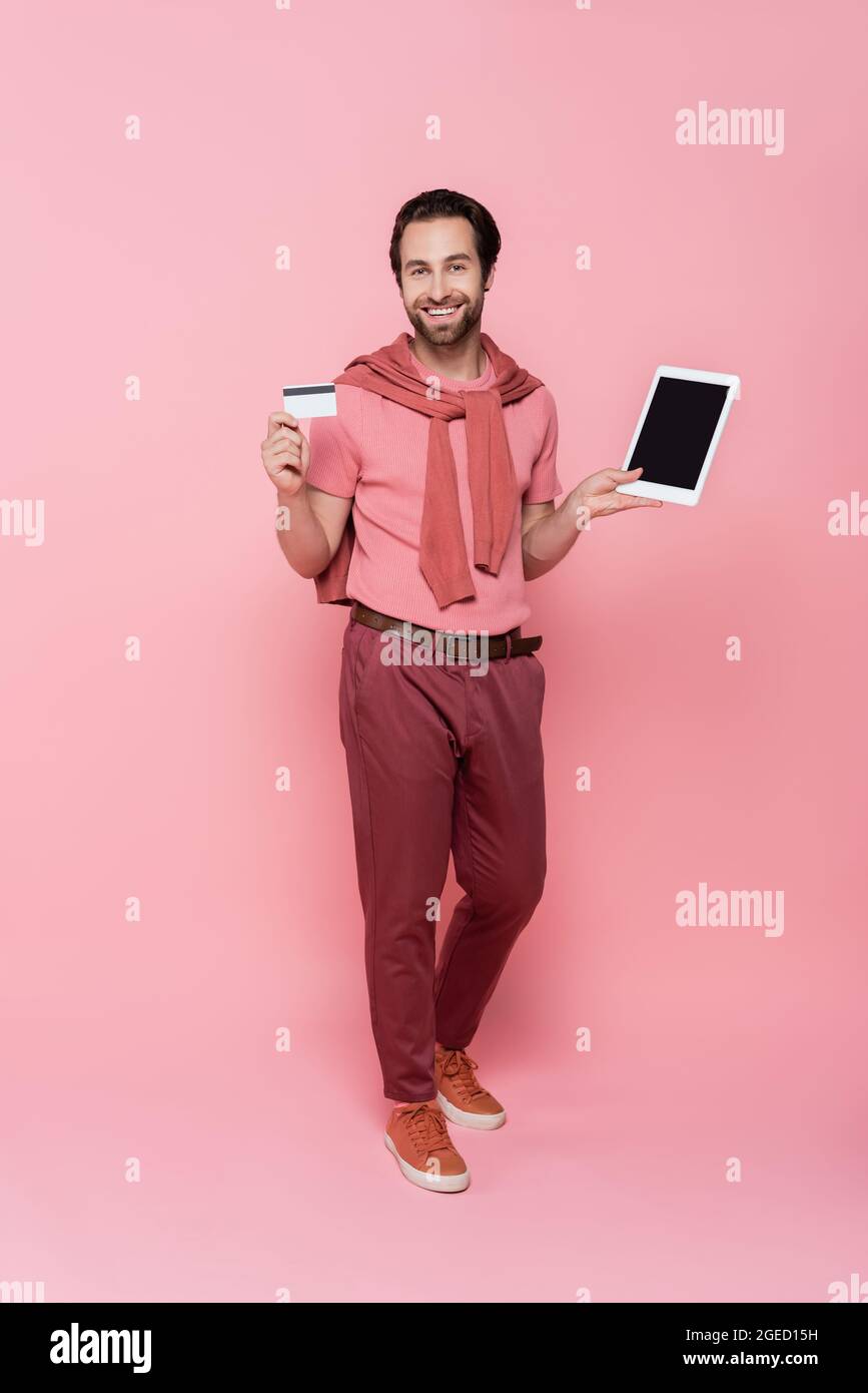 Full length of smiling man holding digital tablet with blank screen and ...