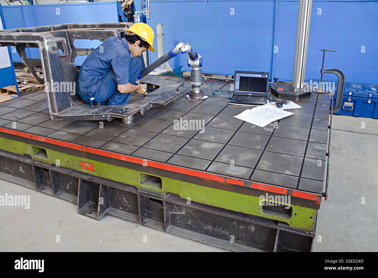 A technician is using a measurement equipment and a laptop in a metal ...