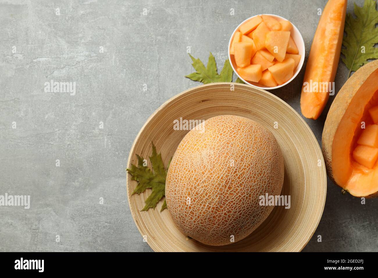 Concept of fresh food with melon on gray textured table Stock Photo - Alamy