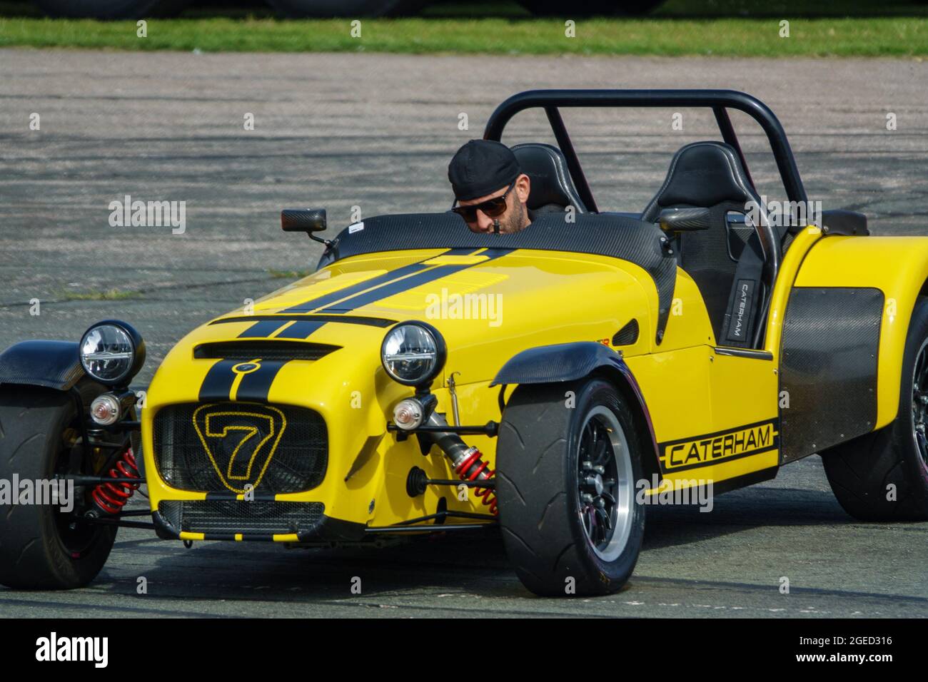 A man sitting in a yellow Caterham sports car at The British Motorshow ...