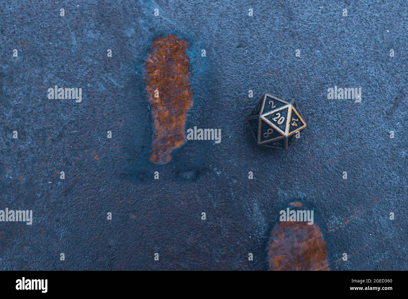 Close-up image of one 20-sided metallic role-playing die on a rusty ...