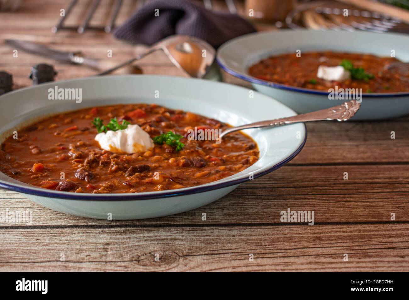 Chili con carne, homemade cooked on rustic enamel plates Stock Photo ...