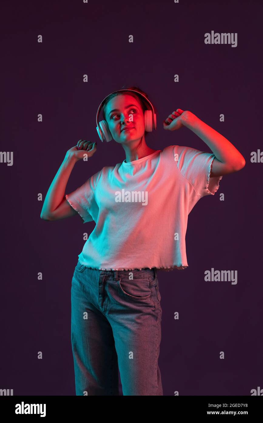 Portrait of pretty romantic girl on dark purple studio background in ...