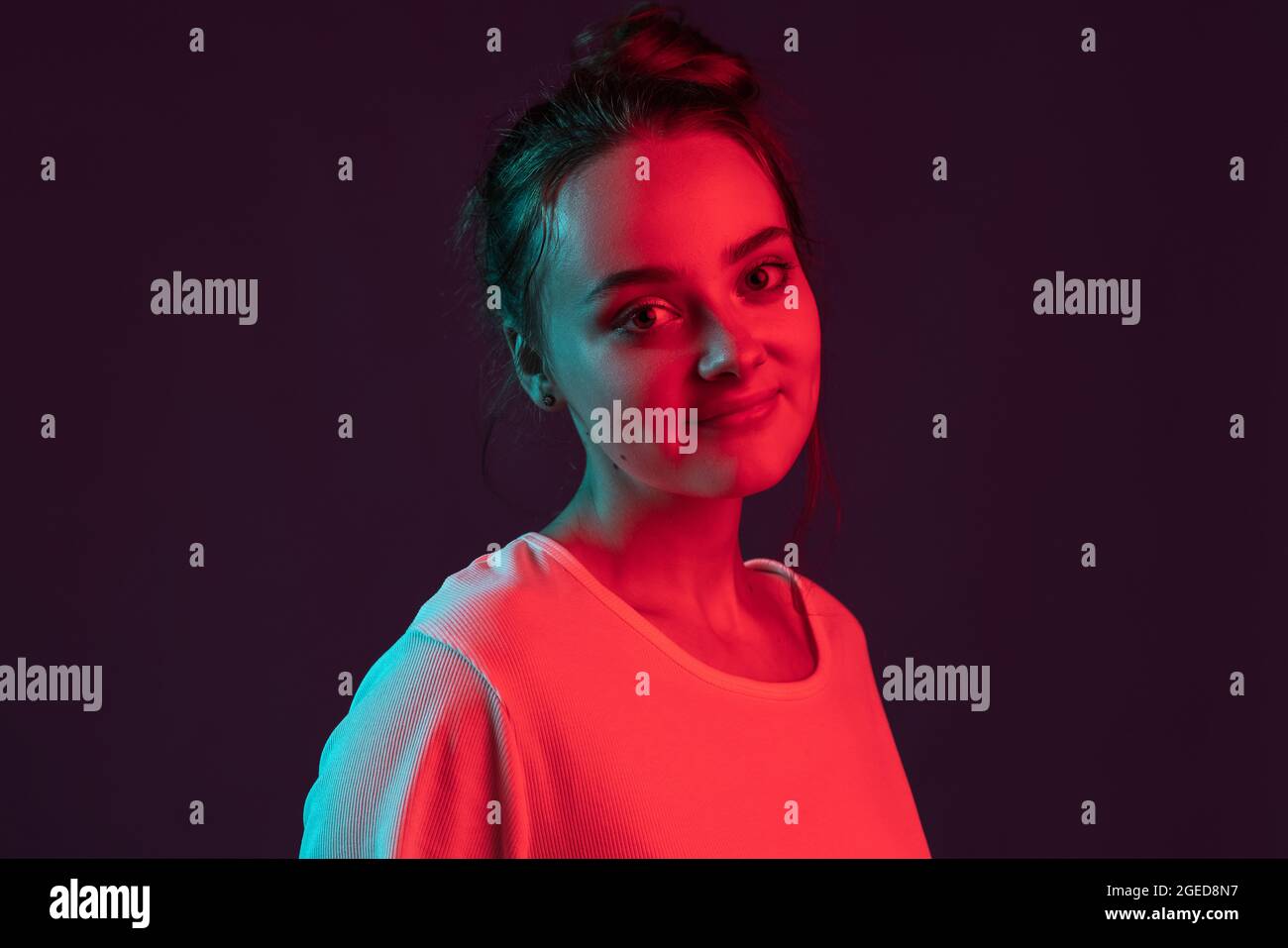 Close up portrait of sweet, pretty romantic girl on dark purple studio ...