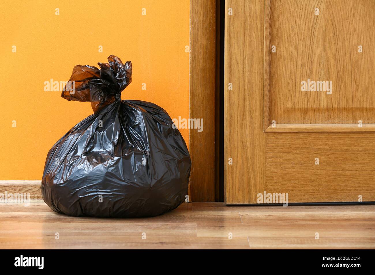 Bag with garbage near door Stock Photo - Alamy