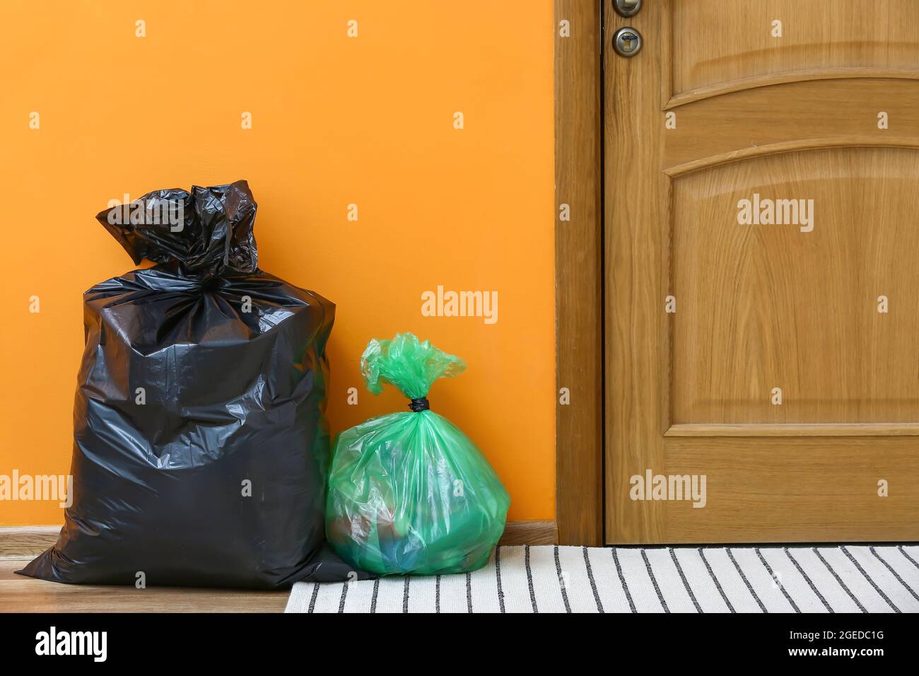 Bags with garbage near door Stock Photo - Alamy