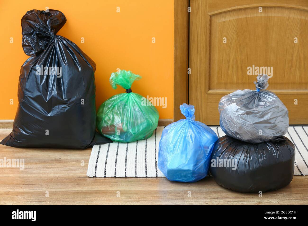 Bags with garbage near door Stock Photo - Alamy