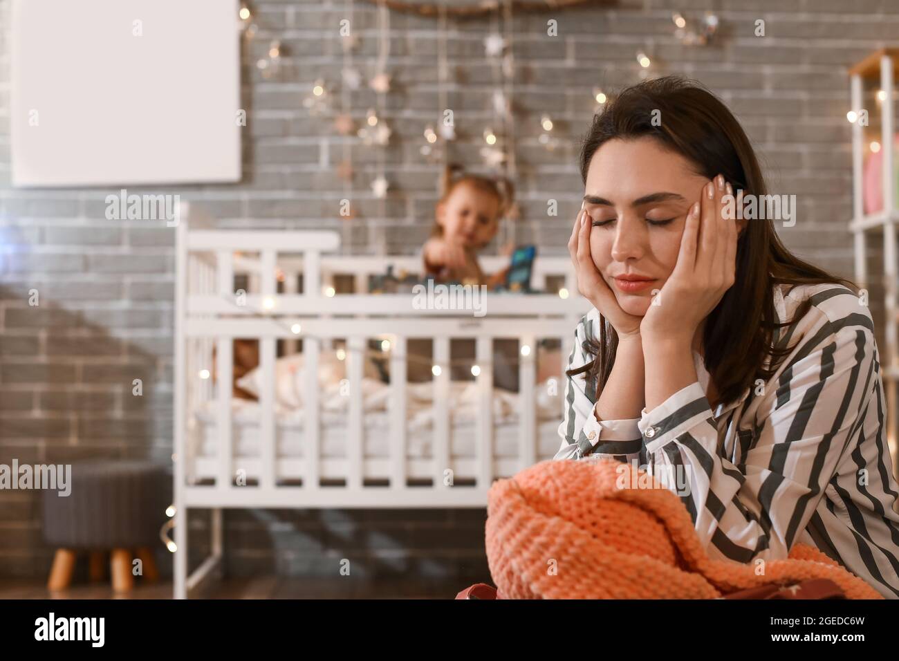 Tired young mother with toy at home Stock Photo - Alamy