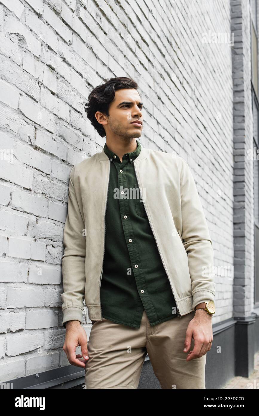 young man in bomber jacket posing near brick wall Stock Photo - Alamy