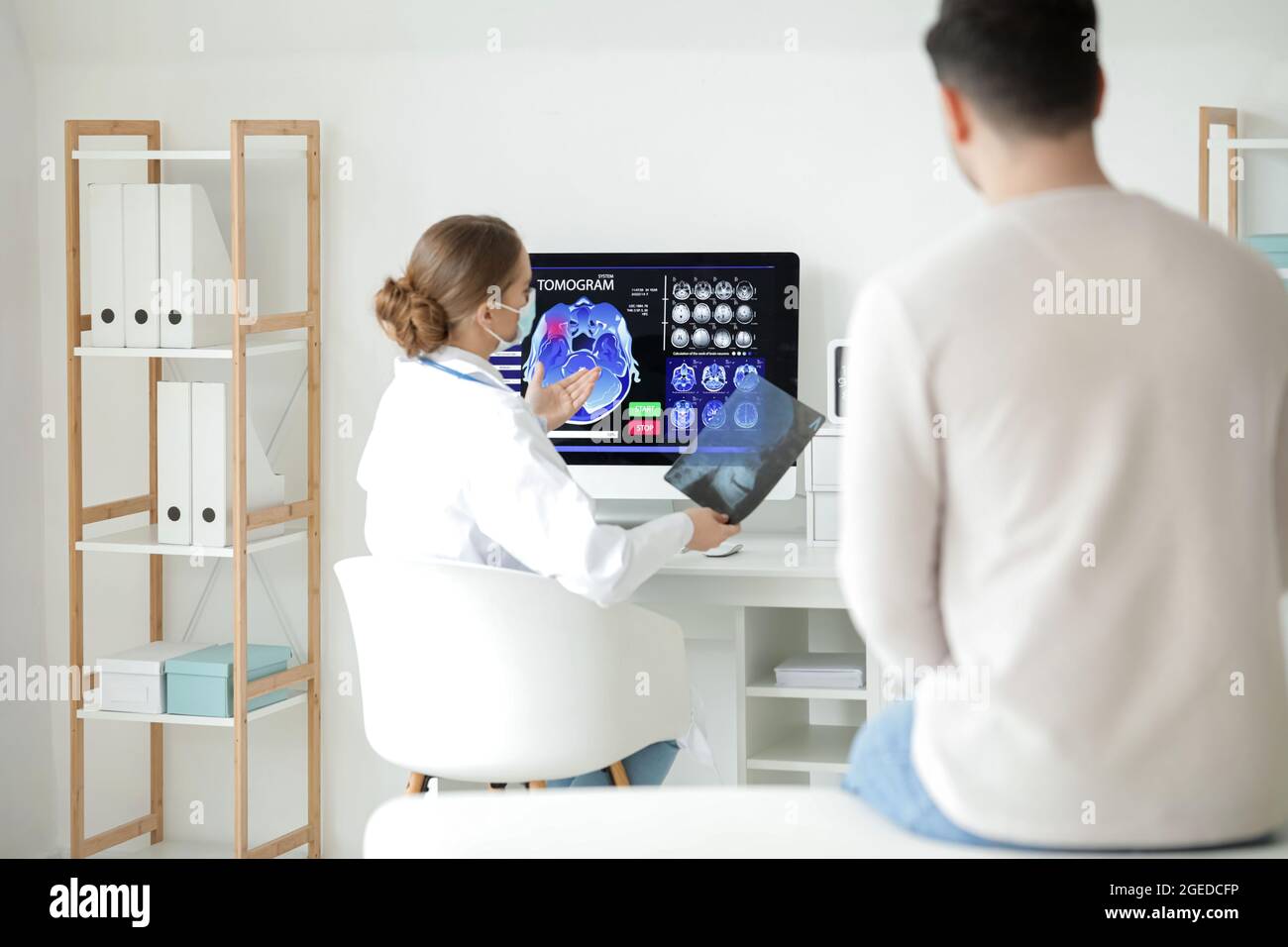 Female doctor showing x-ray scan to patient in clinic Stock Photo - Alamy