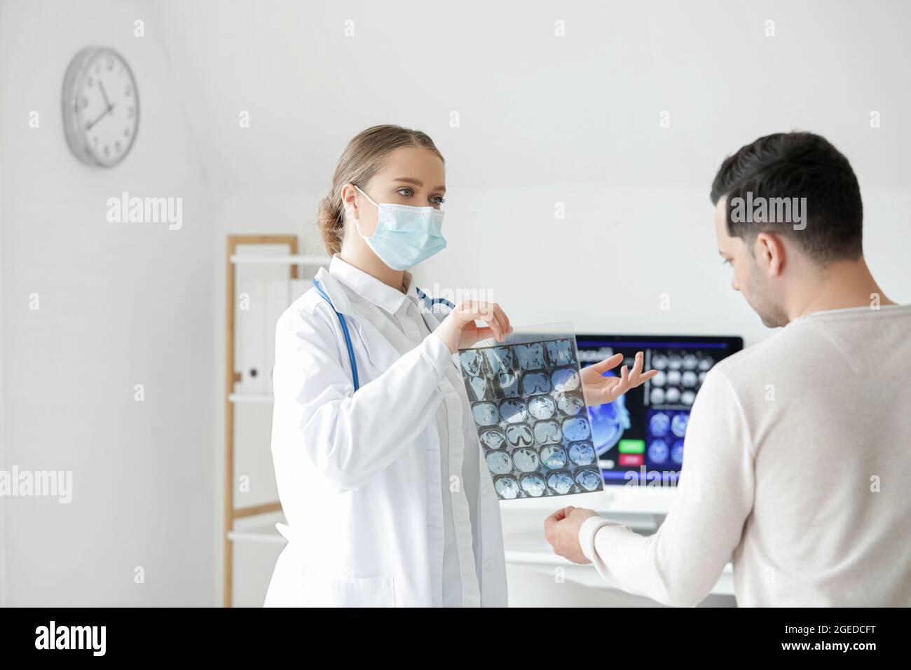 Female doctor showing x-ray scan to patient in clinic Stock Photo - Alamy