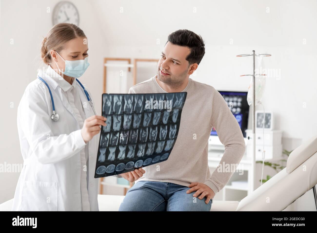 Female doctor showing x-ray scan to patient in clinic Stock Photo - Alamy