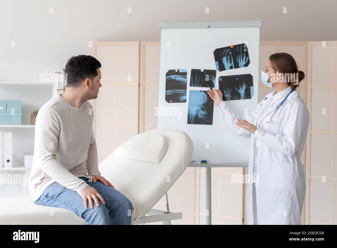 Female doctor showing x-ray scans to patient in clinic Stock Photo - Alamy