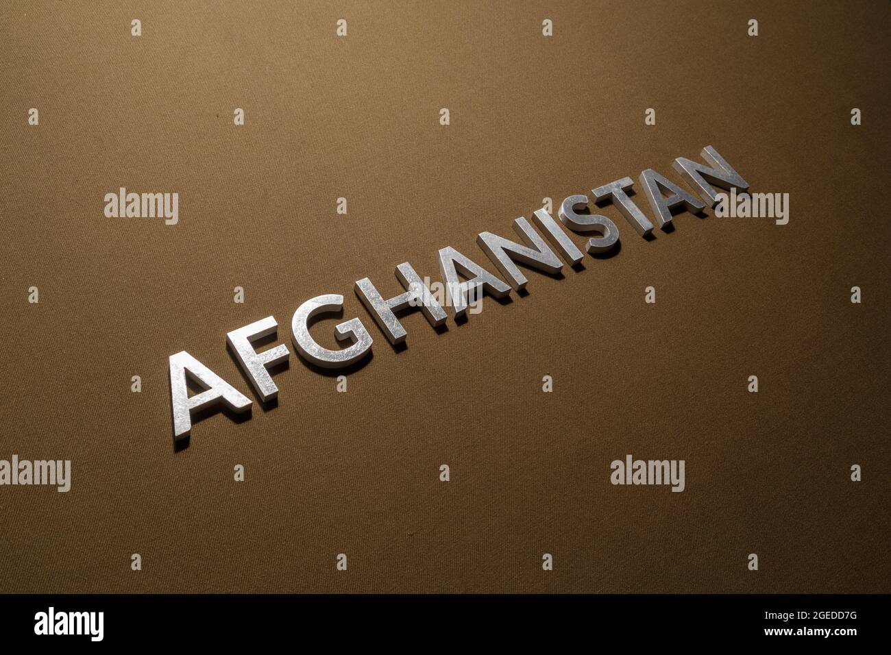 the word afghanistan laid with silver metal letters on rough tan khaki ...