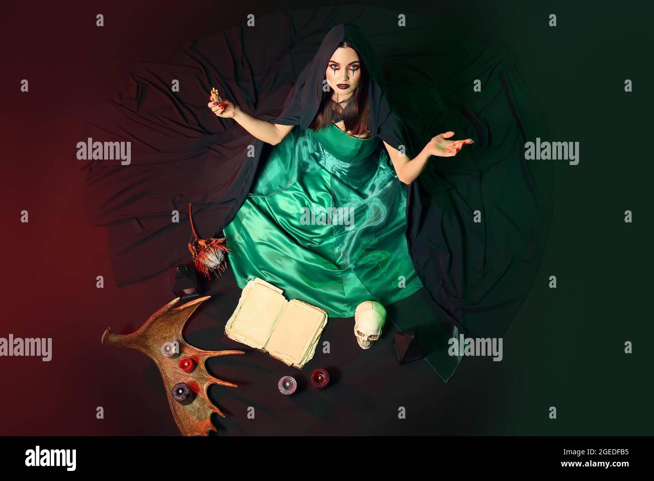 Young witch performing ritual on dark background Stock Photo - Alamy