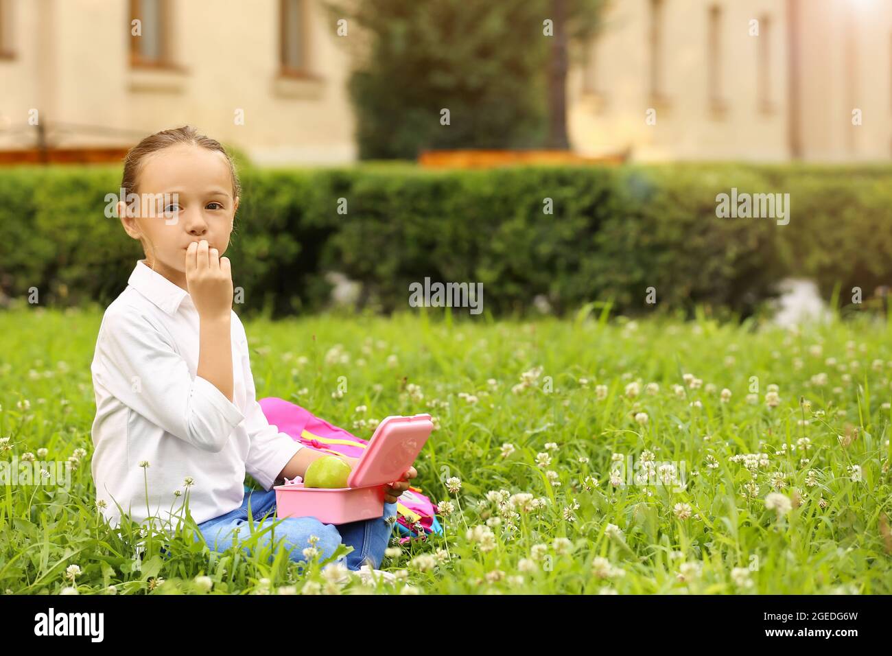 Cute little girl having school lunch outdoors Stock Photo - Alamy