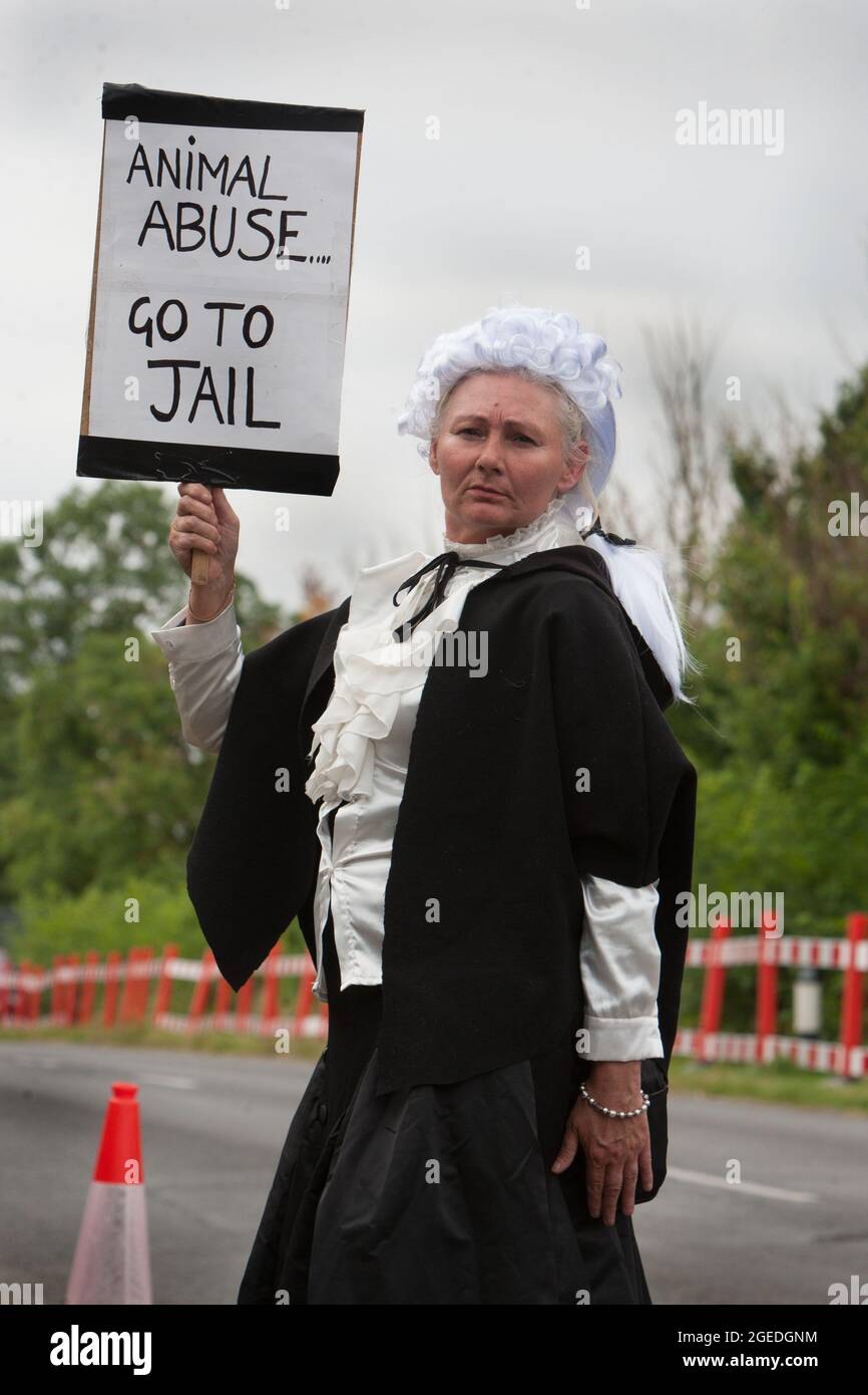 A protester dressed as a judge holds up a sign reading "Animal Abuse ...