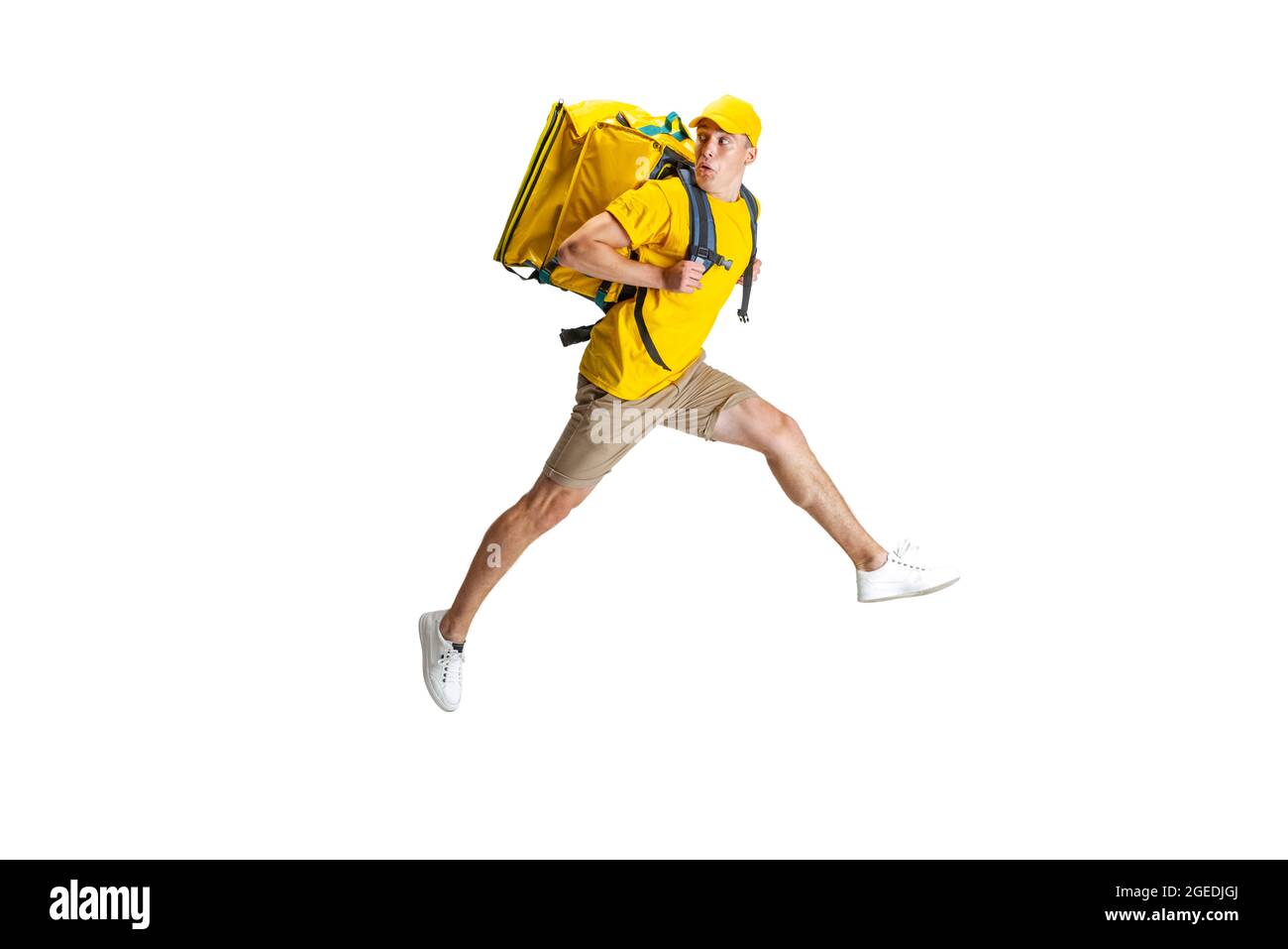 Young delivery man in yellow uniform hurry up to deliver order isolated ...